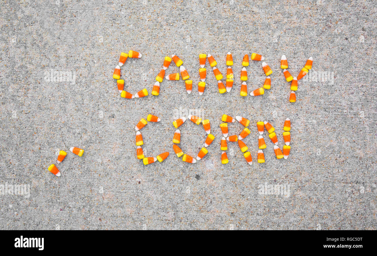 The words Candy Corn spelled out with candy corn on a sidewalk with ...