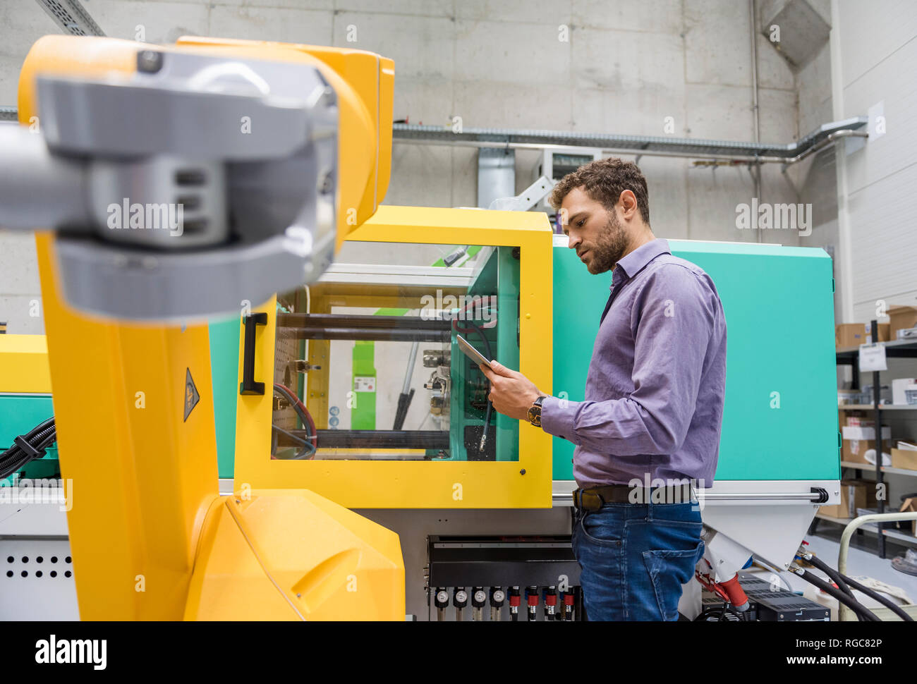 Businessman checking industrial robot in high tech company Stock Photo ...