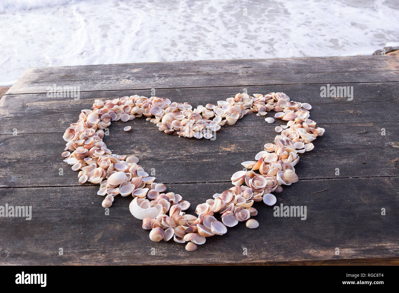 Heart formed by seashells on boardwalk Stock Photo - Alamy