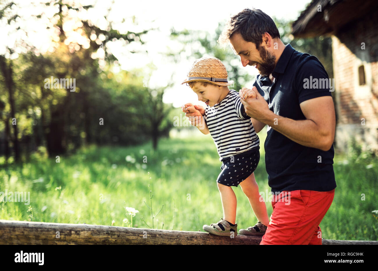 Father assisting his little son in balancing on a fence Stock Photo - Alamy