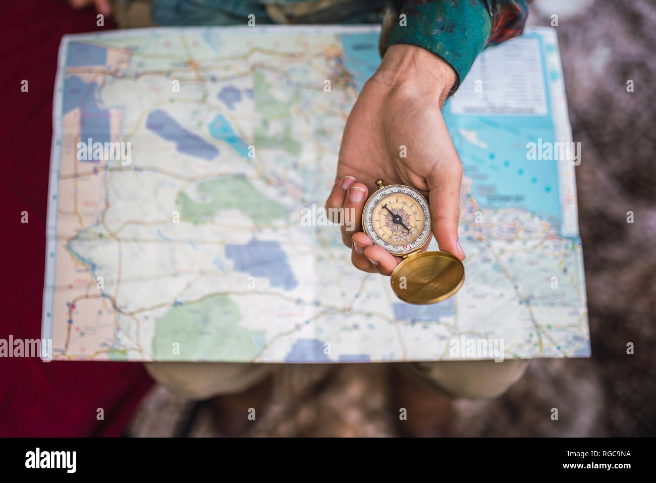Hand holding compass over map Stock Photo - Alamy