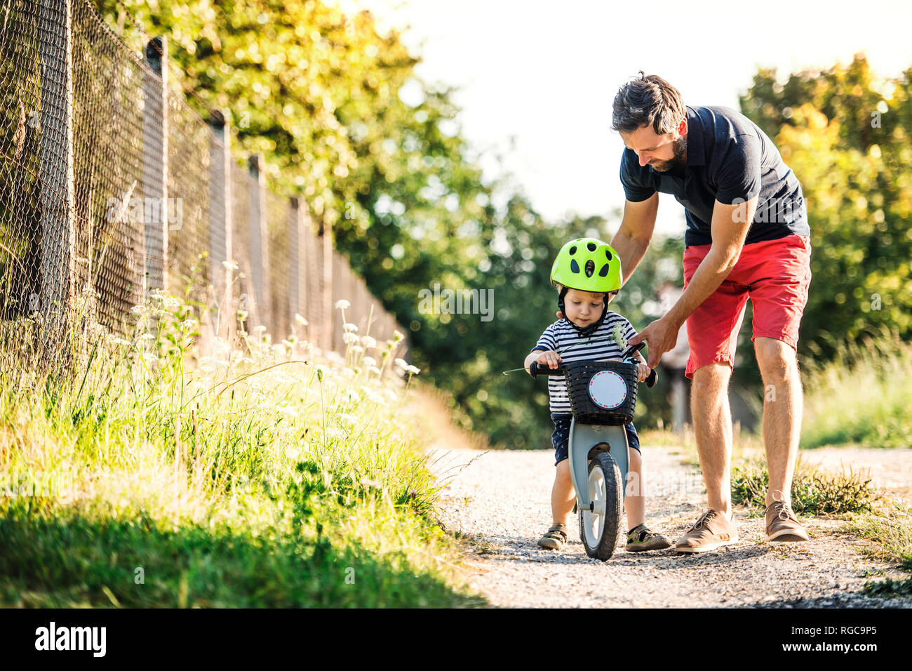 Father teaching little son riding bicycle Stock Photo - Alamy