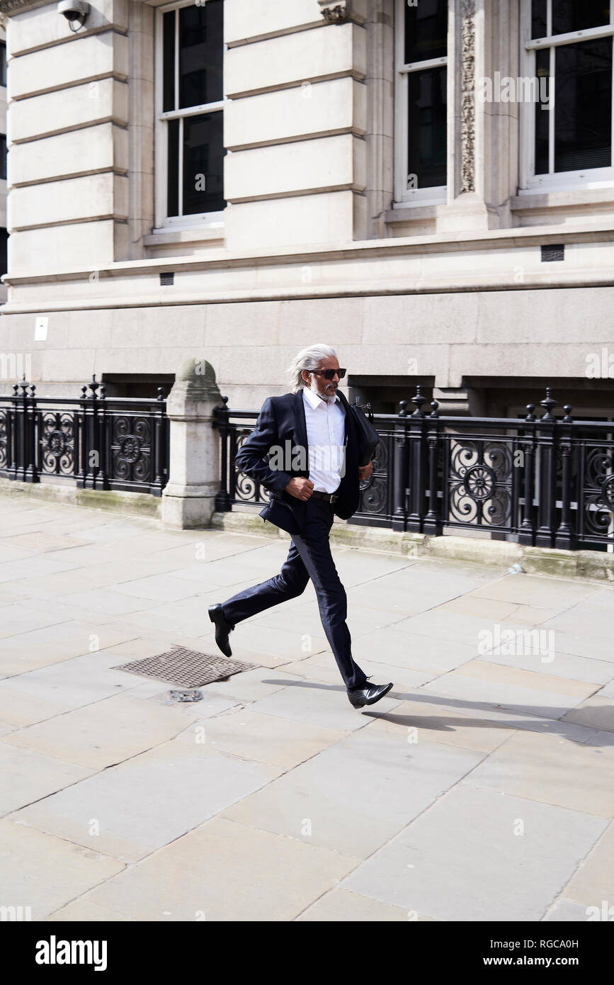Senior businessman running on pavement in the morning Stock Photo - Alamy