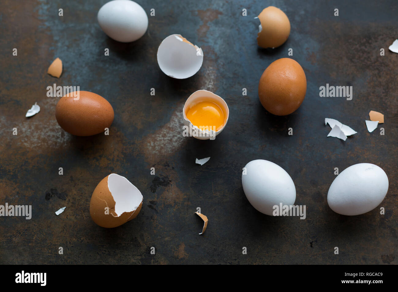 Whole and opened white and brown eggs on rusty metal Stock Photo - Alamy