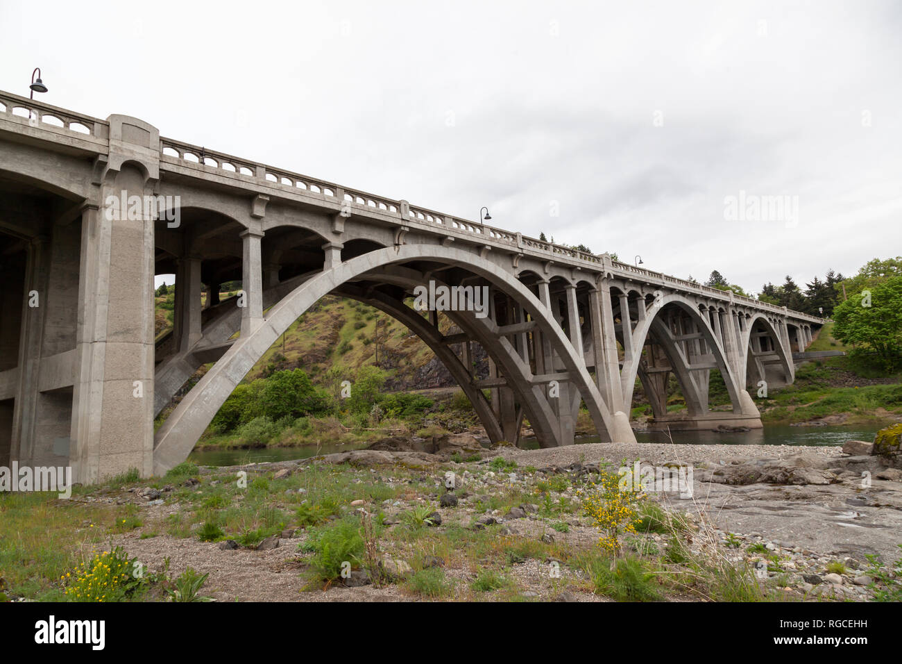 A concrete arch bridge spanning over the green waters on the South ...