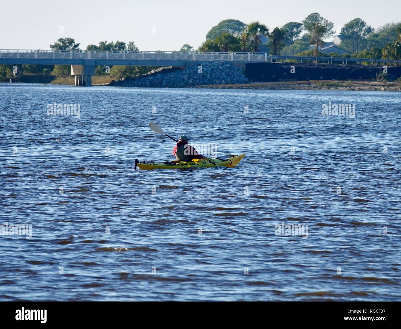 Man in yellow kayak, paddling protected area along the edge of the Gulf ...