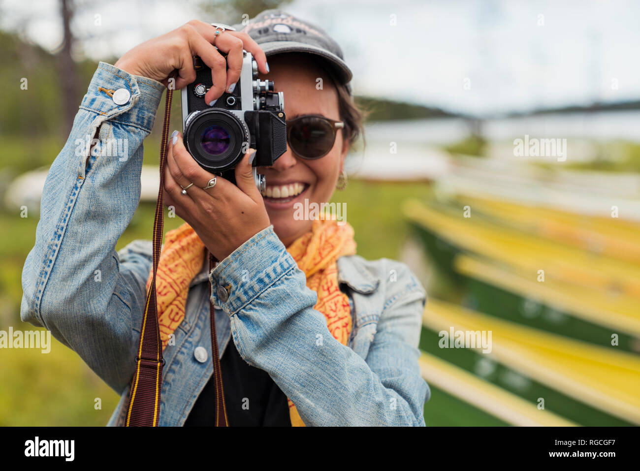 Finland, Lapland, portrait of smiling young woman taking picture with a ...