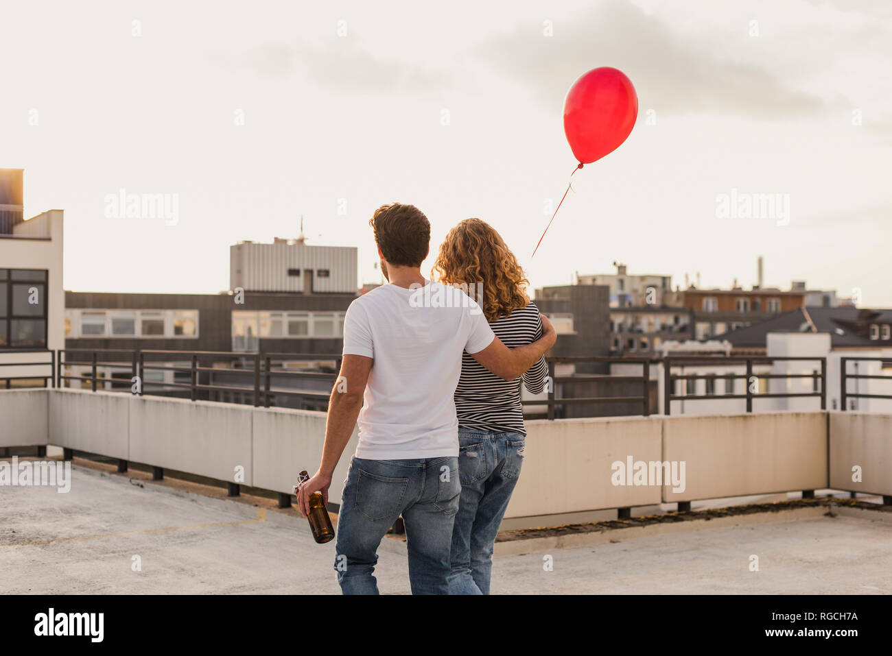 Back view of young couple on roof terrace at evening twilight Stock ...