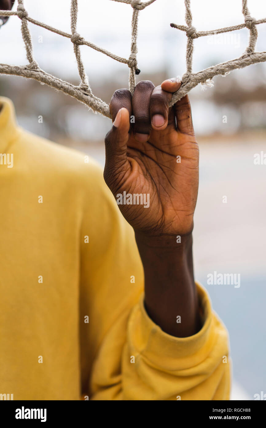 Hand holding on to volleyball net Stock Photo - Alamy