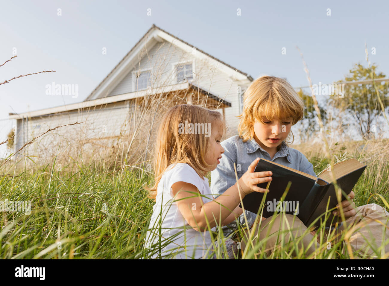 Sister reading book hi-res stock photography and images - Alamy