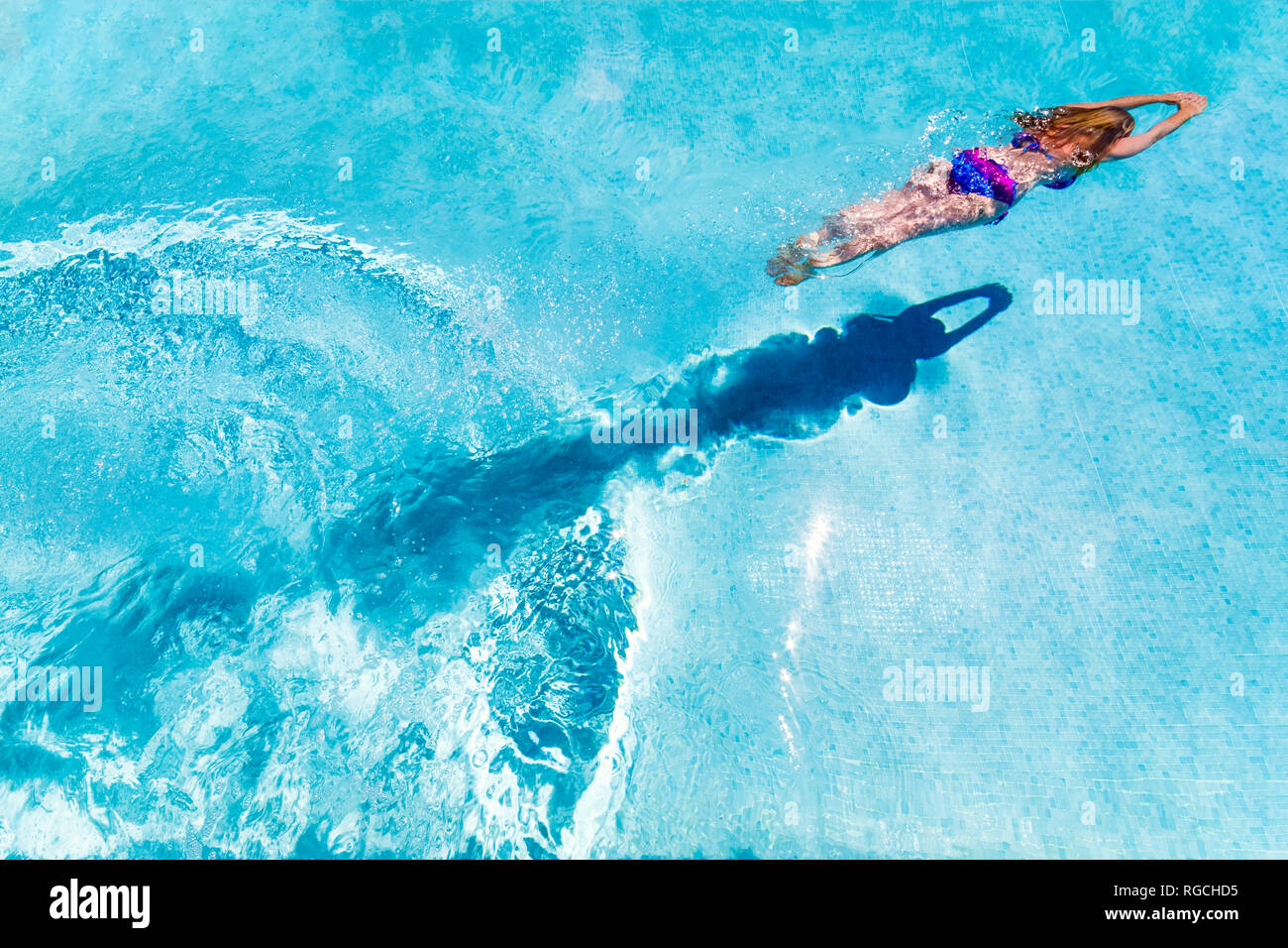 Woman diving into swimming pool creating bubbles hi-res stock ...