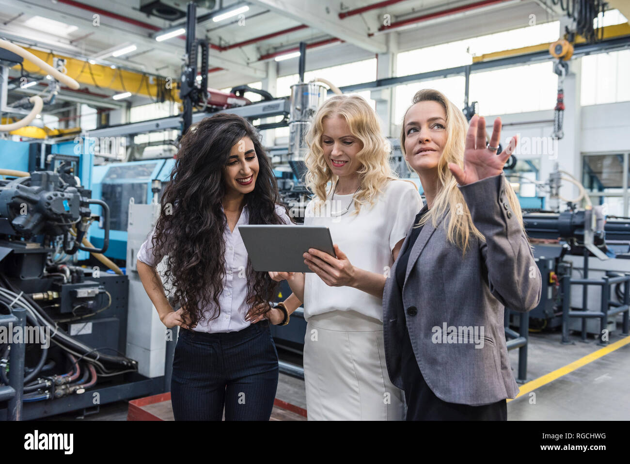 Three women with tablet talking in factory shop floor Stock Photo - Alamy