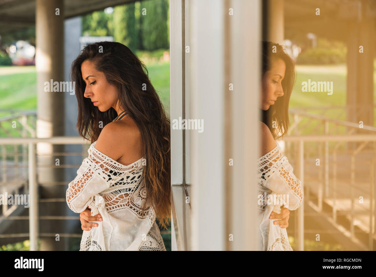 Serious brunette young woman at a window outdoors Stock Photo - Alamy