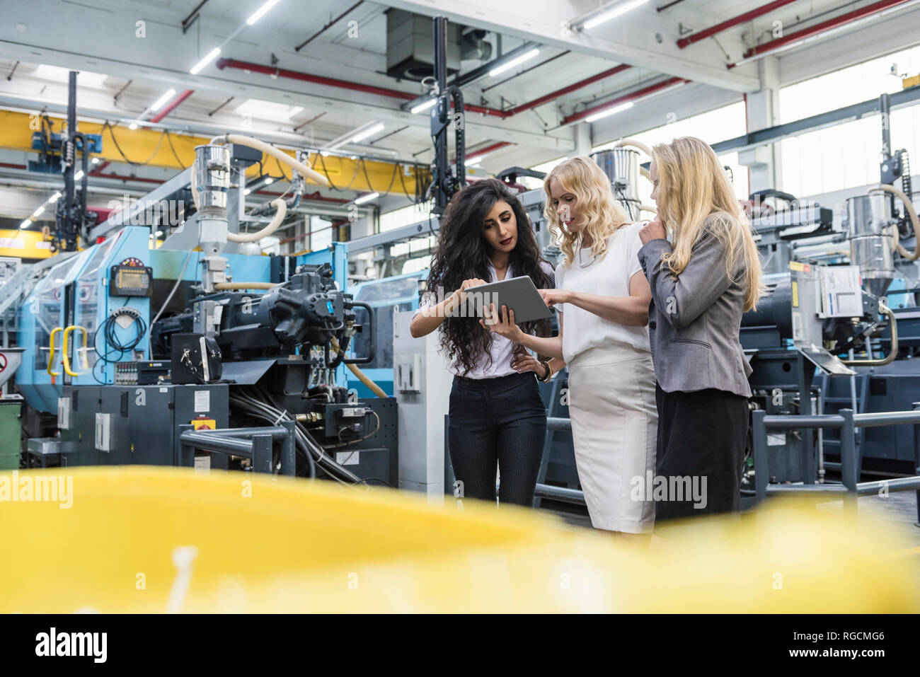Three women with tablet talking in factory shop floor Stock Photo - Alamy