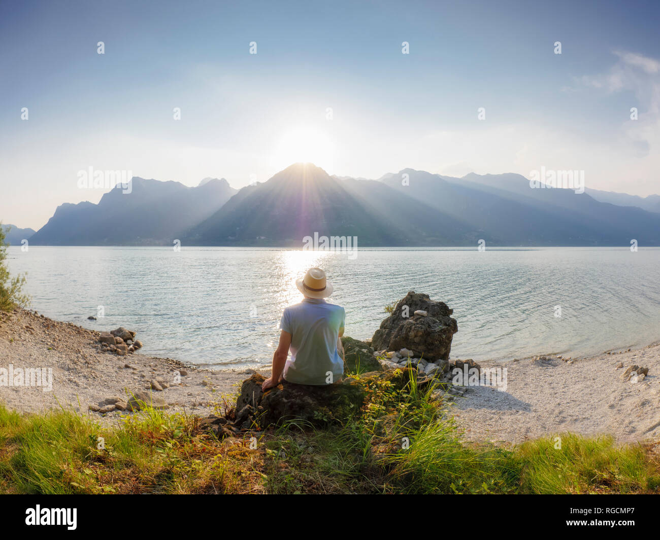 Back view man sitting lake idro sunset hi-res stock photography and ...
