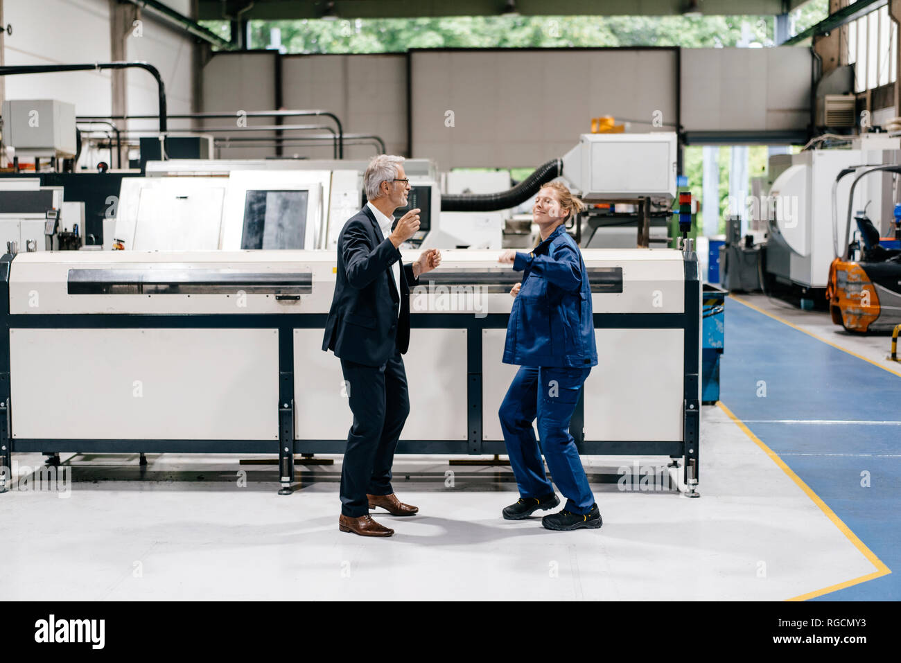 Manager and skilled worker dancing in factory workshop, having fun ...