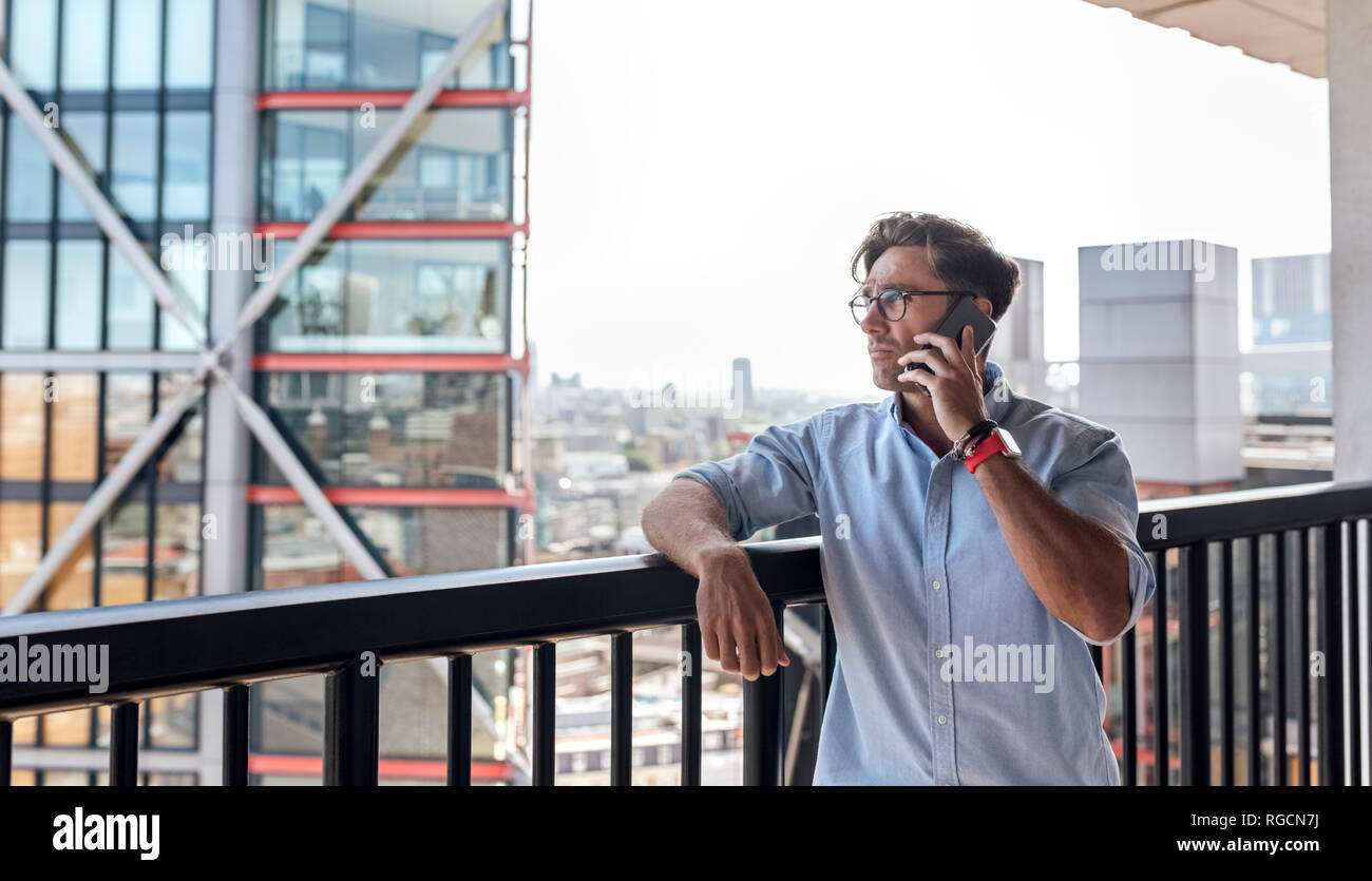 UK, London, man on the phone on a roof terrace Stock Photo - Alamy