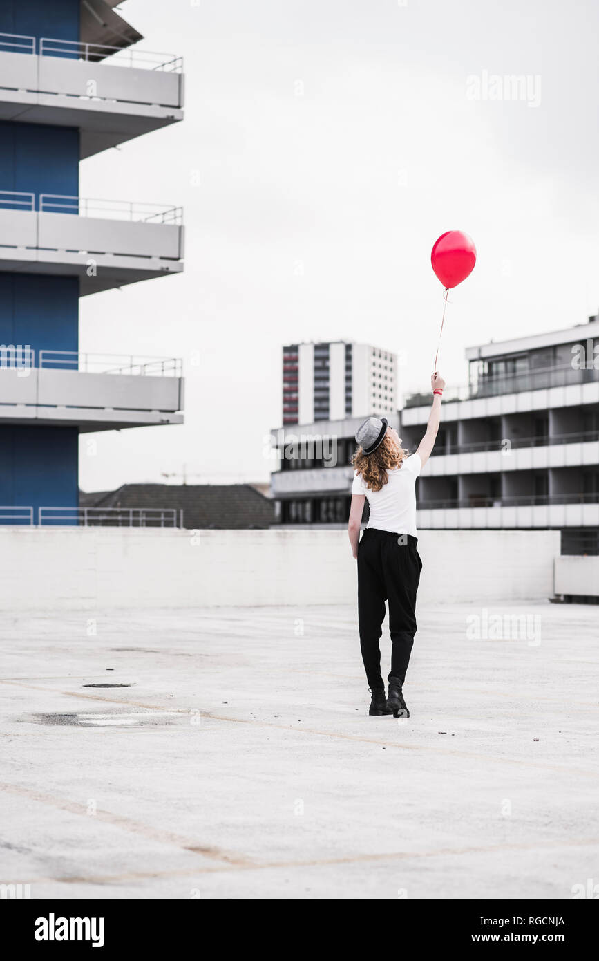 Back view of young woman with red balloon Stock Photo - Alamy