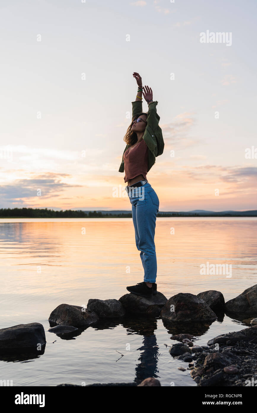 Finland, Lapland, woman standing at the lakeside at twilight Stock ...