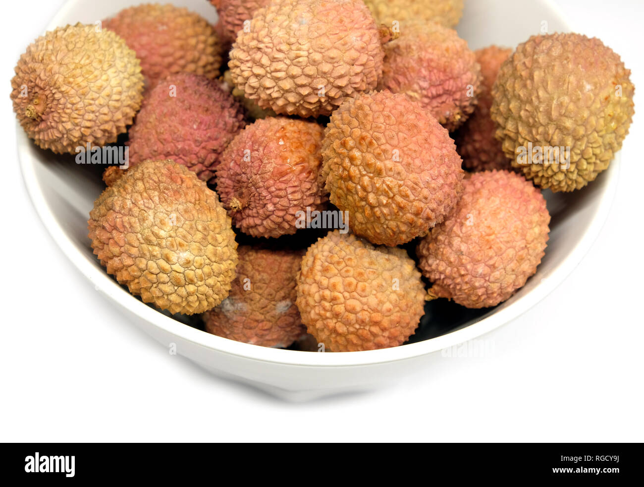 Many ripe lychee fruits isolated in white bowl top view closeup Stock ...