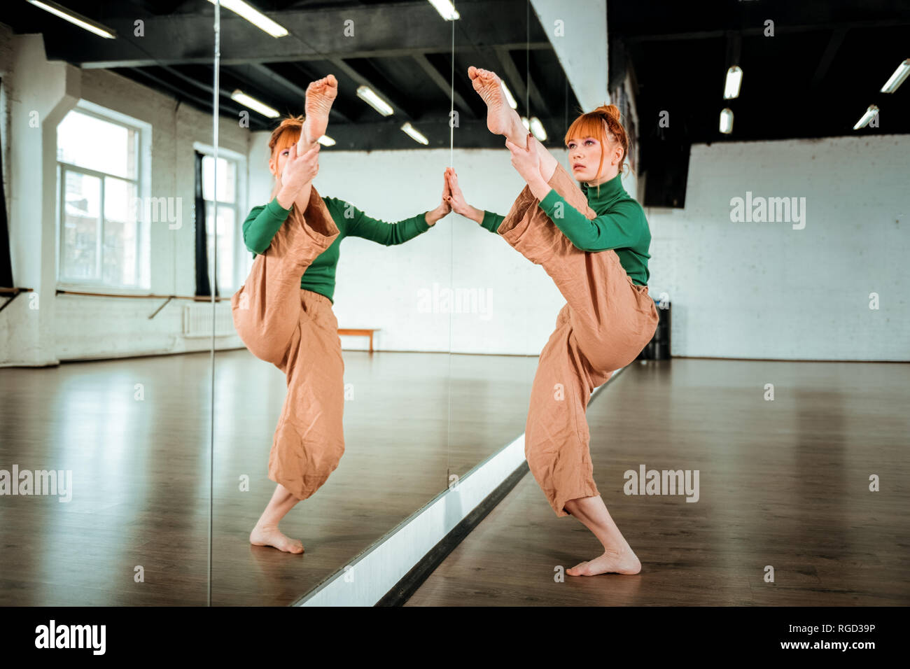 Beautiful professional modern dancer with red hair looking concentrated ...
