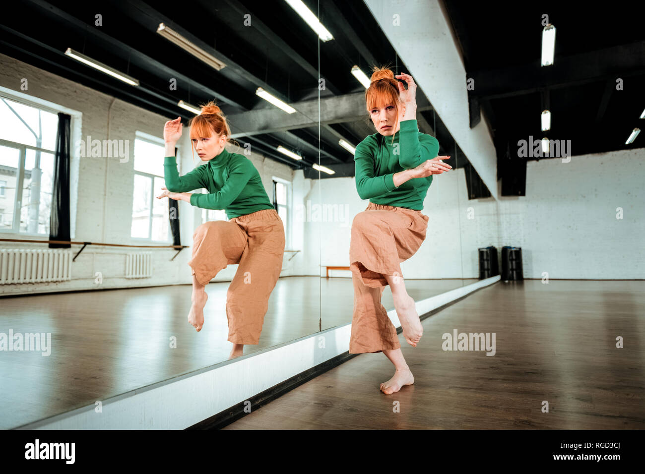 Beautiful professional modern dancer with red hair dancing near the ...