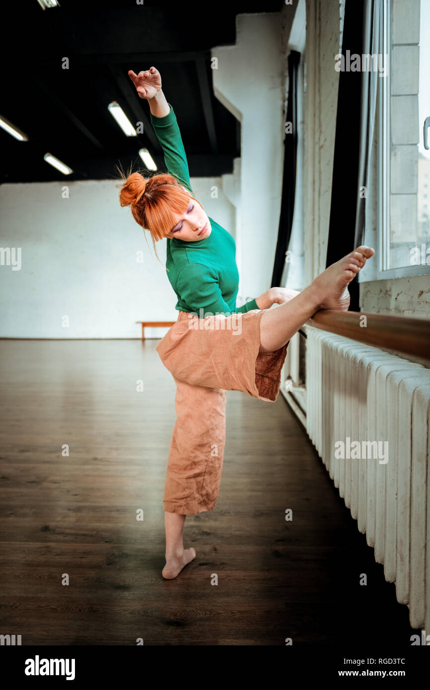 Young professional ballet dancer with hair bun doing inclination Stock ...