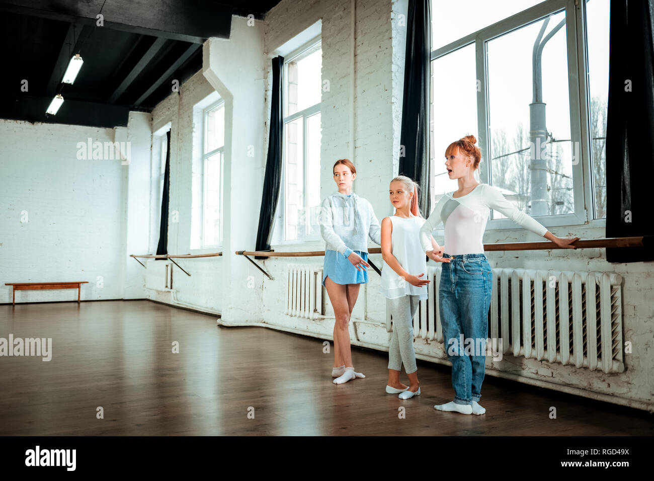 Red-haired ballet teacher and her students standing in the third ballet ...