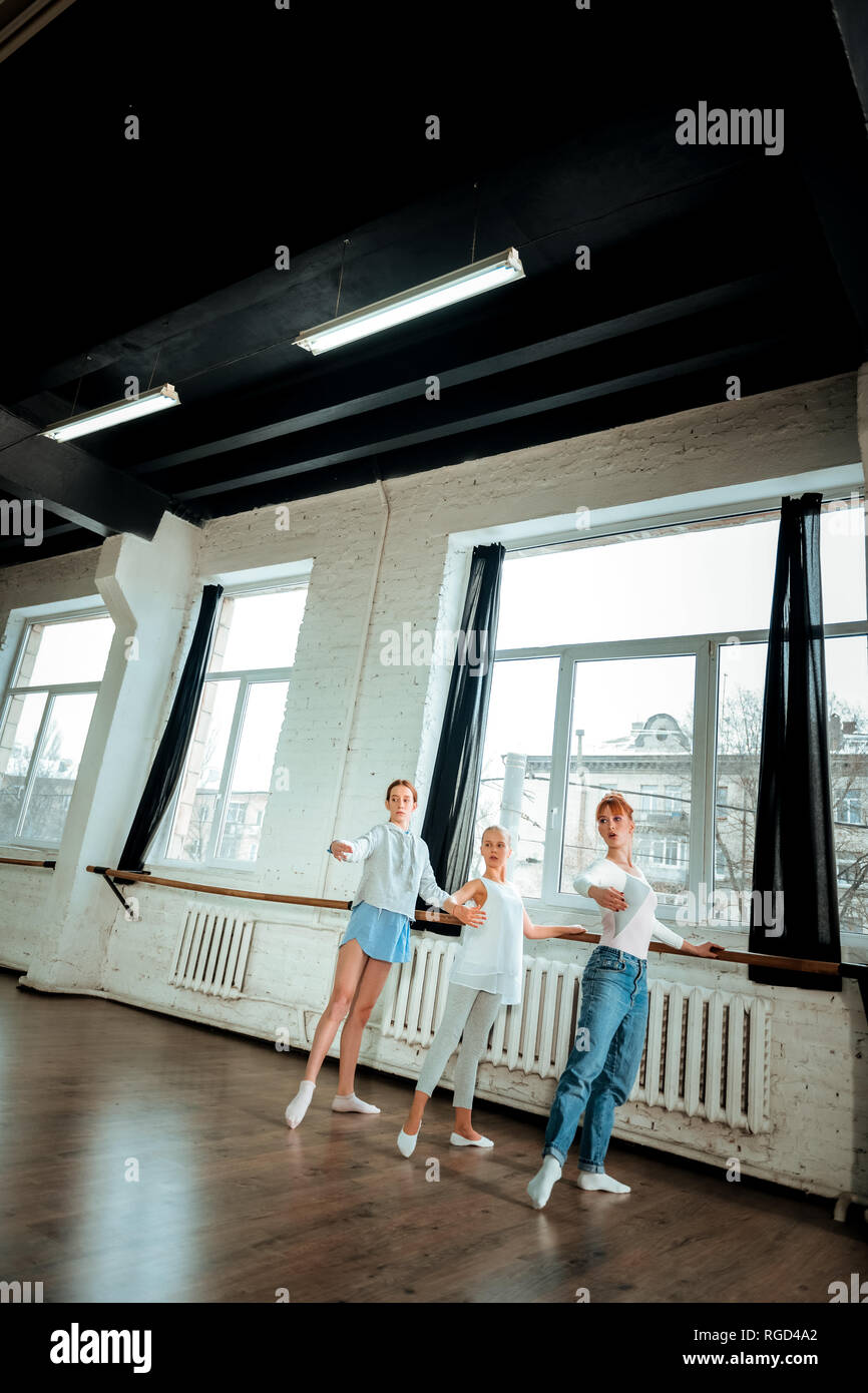 Red-haired ballet teacher and her students leaning their bodies Stock ...