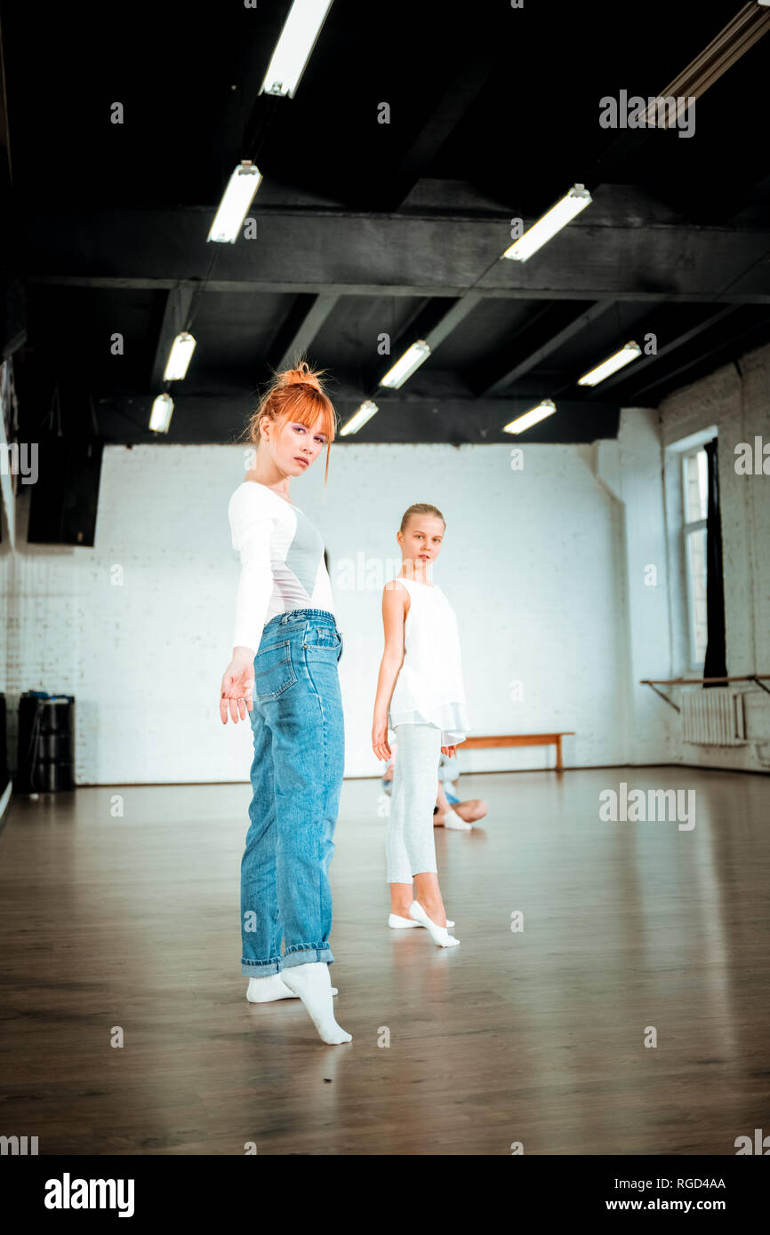 Red-haired ballet teacher and her student dancing in the studio Stock ...