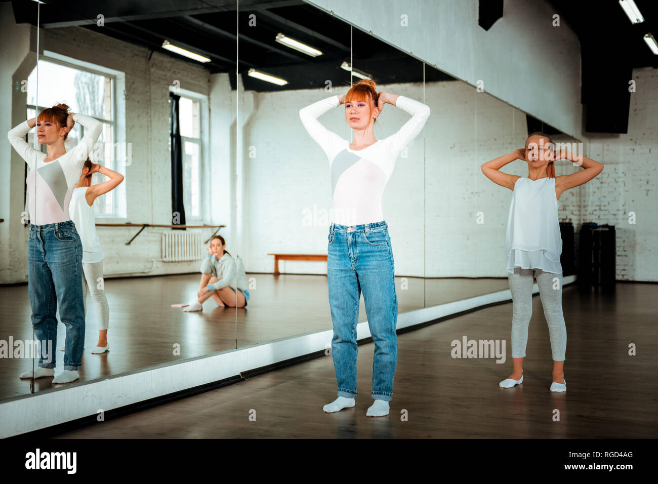 Red-haired ballet teacher and her student dancing near the mirror Stock ...