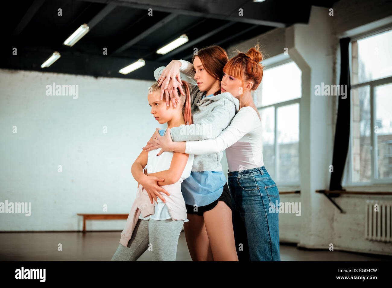 Red-haired young dance teacher and her students standing in front of ...