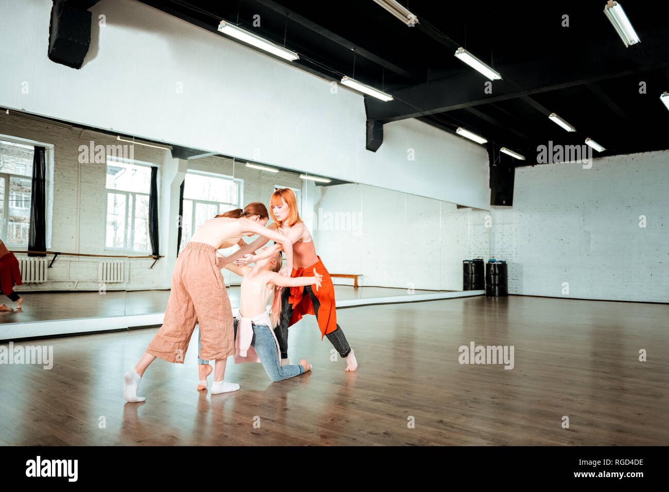 Two students of a dance school and their teacher working out new moves ...