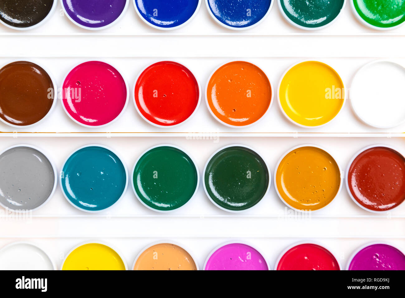 top view white palette with paints lie isolated on bright background ...