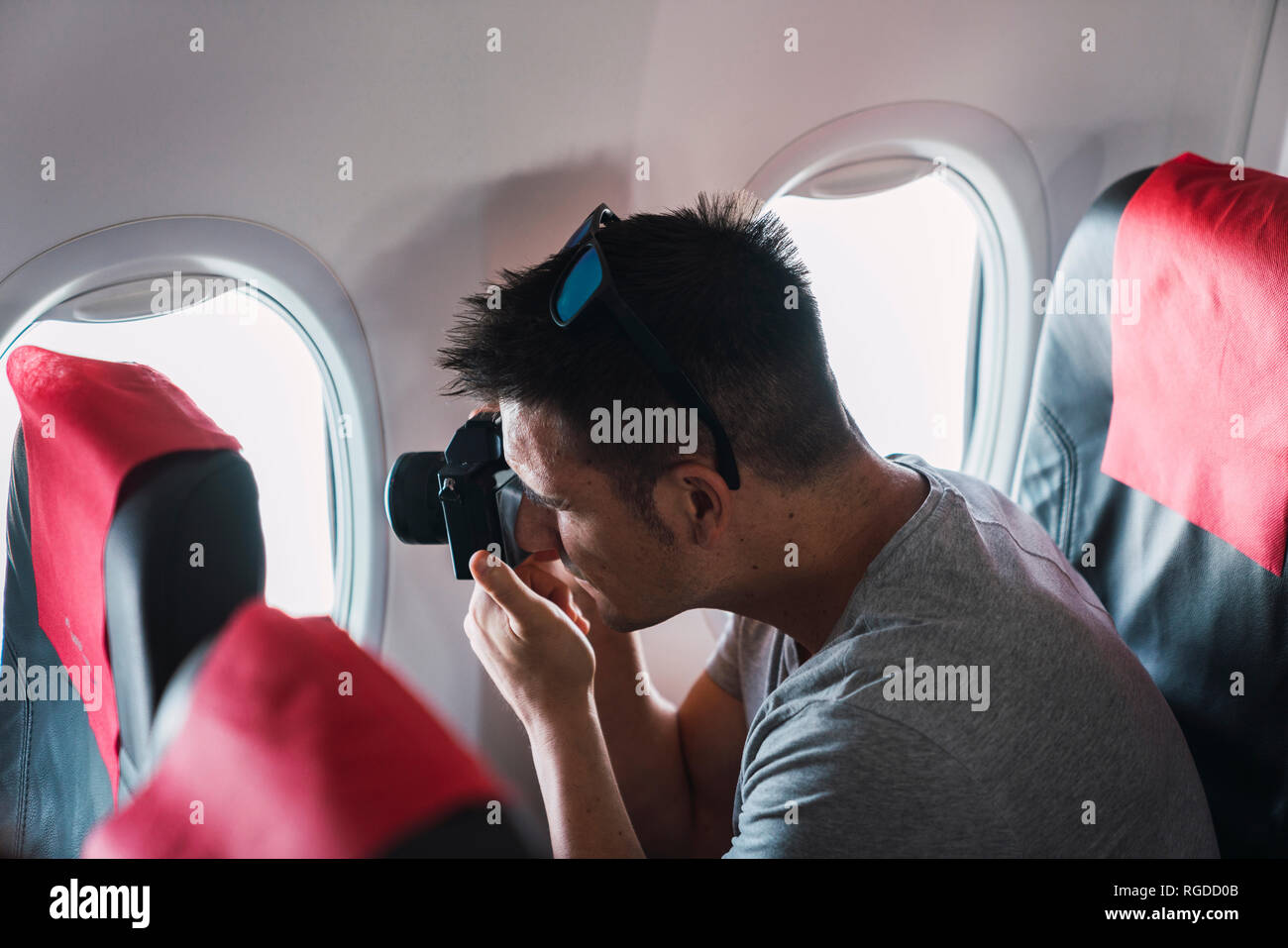 Man taking a picture in airplane Stock Photo - Alamy