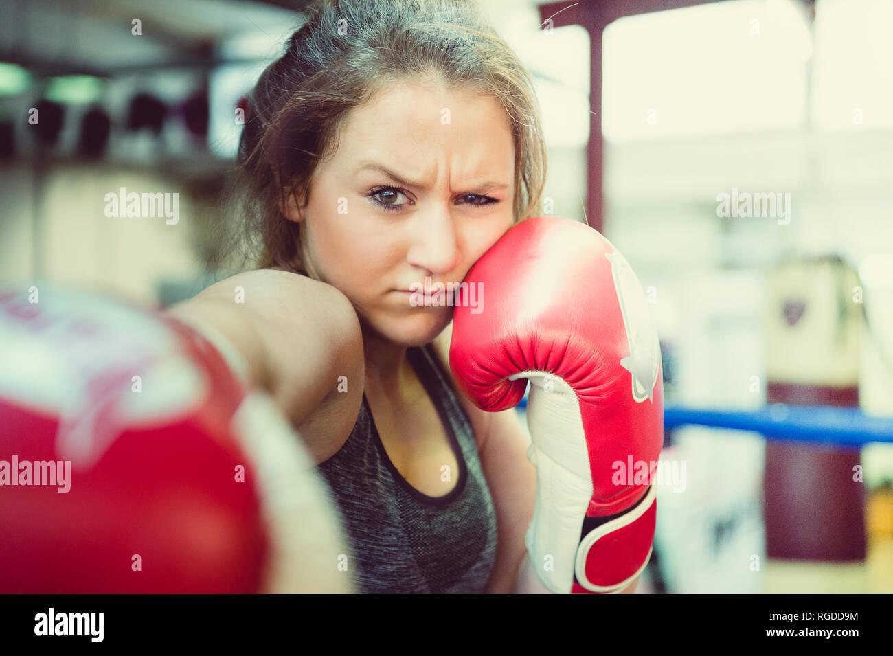 Portrait of a young female boxer punching Stock Photo - Alamy