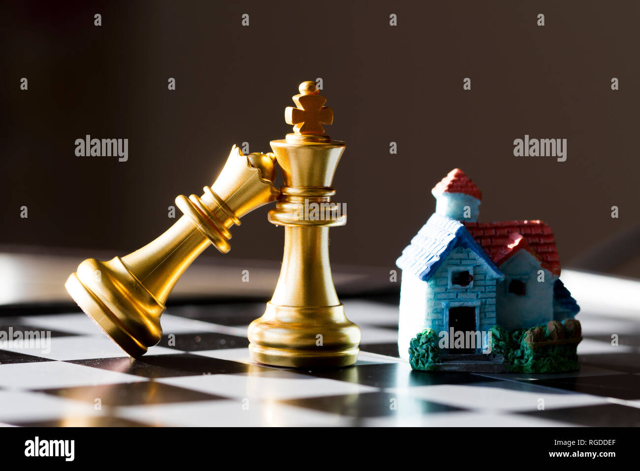Small house with chess pieces Stock Photo - Alamy