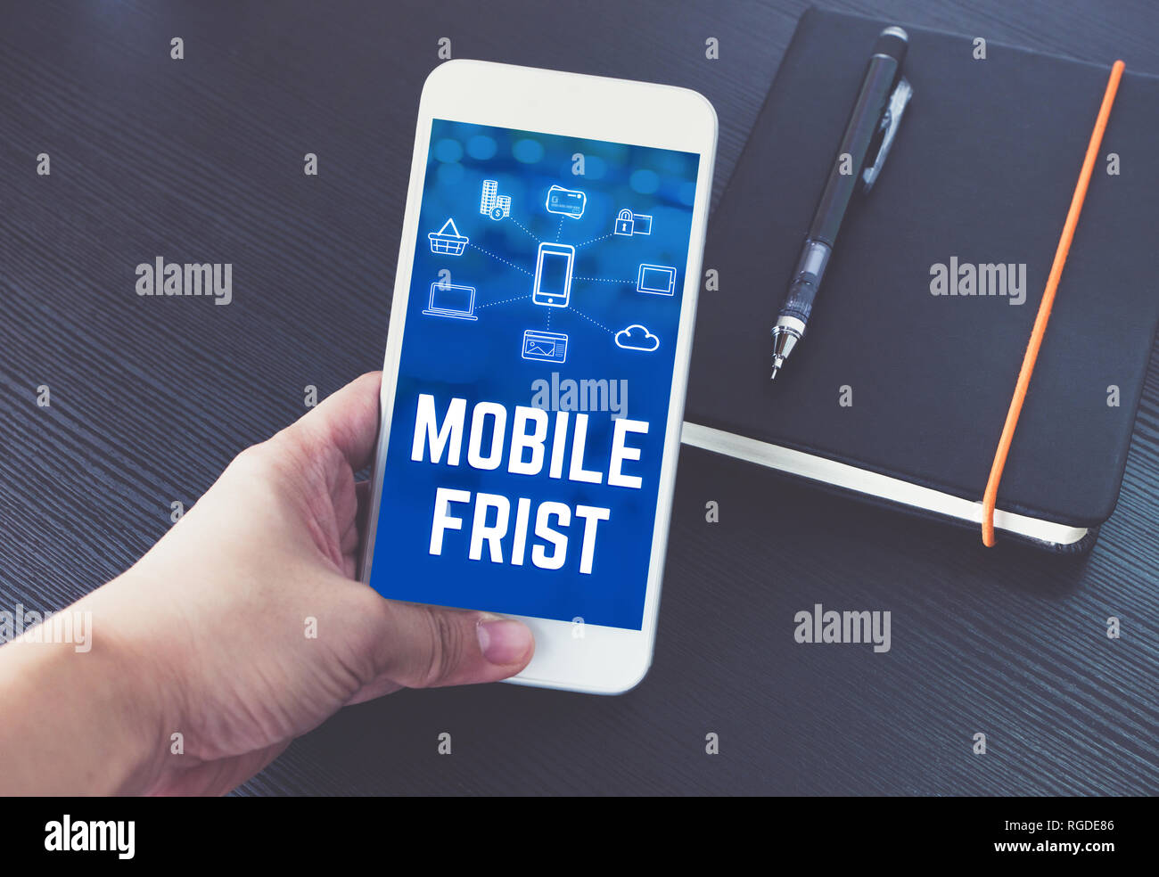 Hand holding mobile phone with mobile first word and feature icon over ...