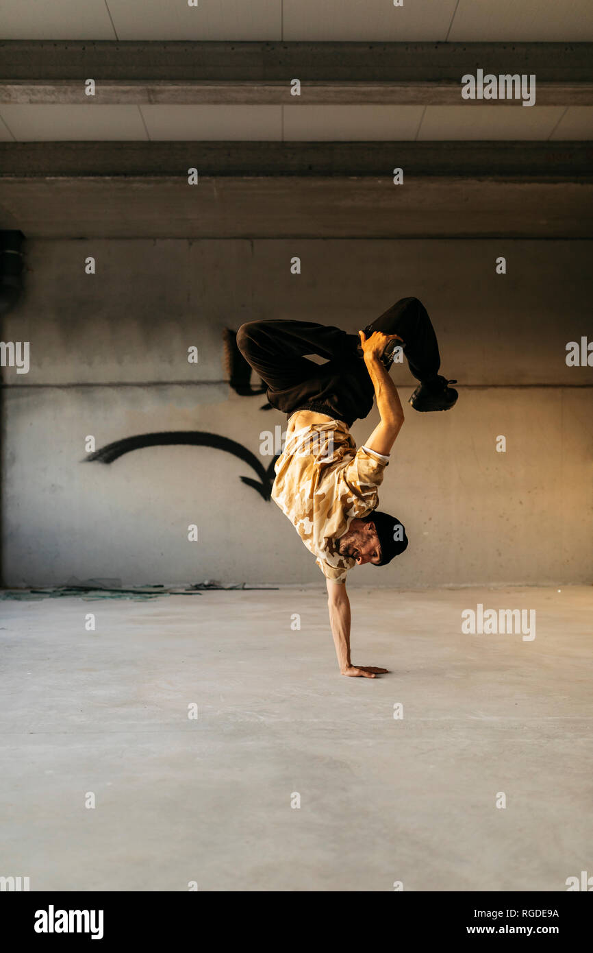 Man doing breakdance in urban concrete building, standing on hand Stock ...