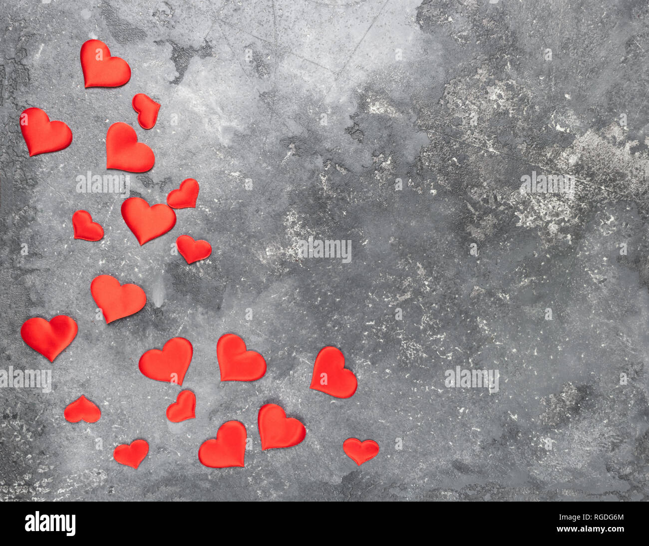 Red hearts are scattered on a gray textured background. Flat layout ...