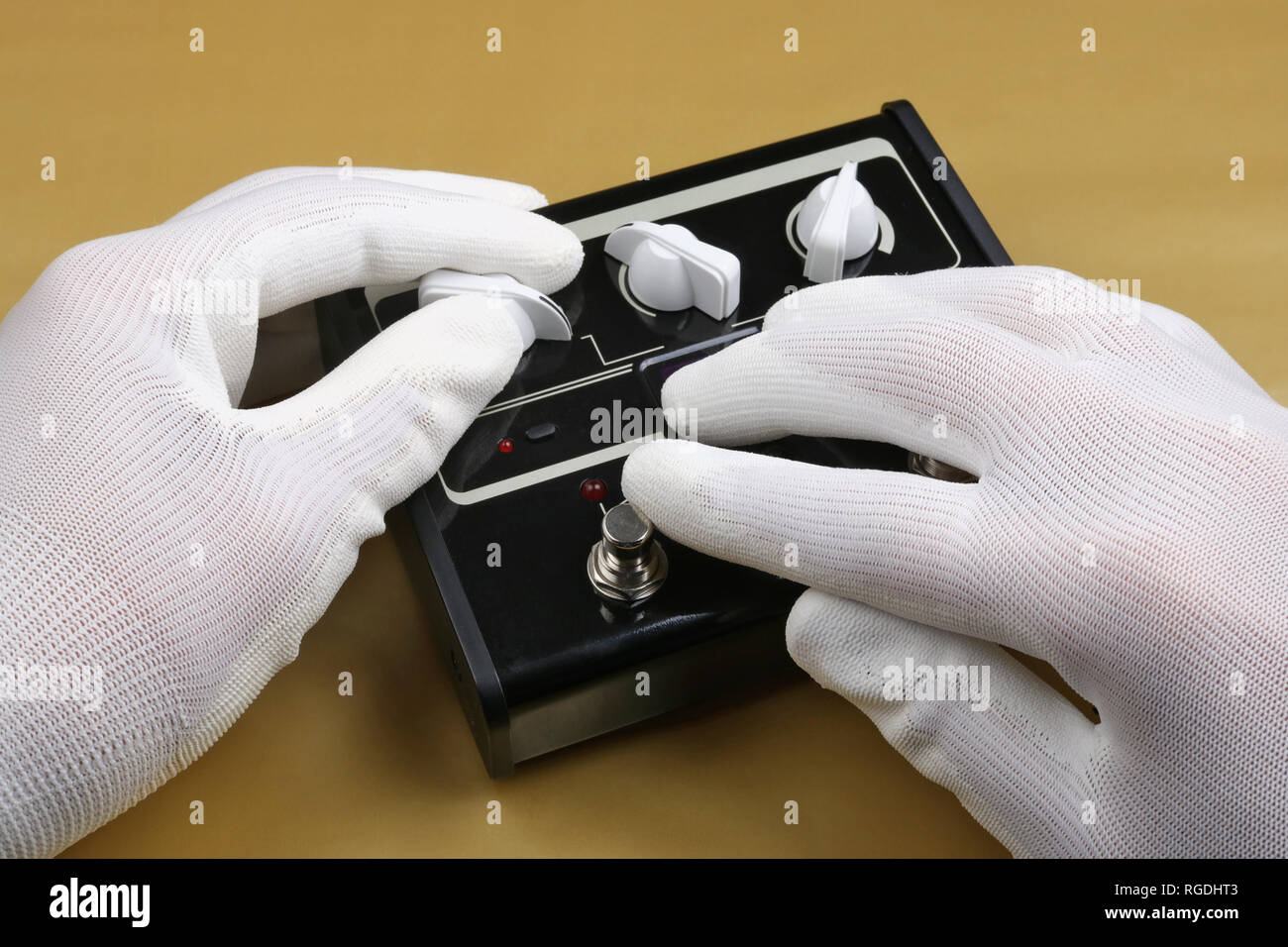 A technician checks a black electrical box with switches and regulators ...