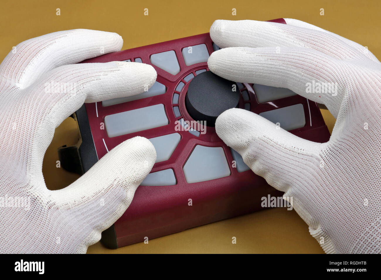 A technician checks a red electrical box with switches and regulators ...