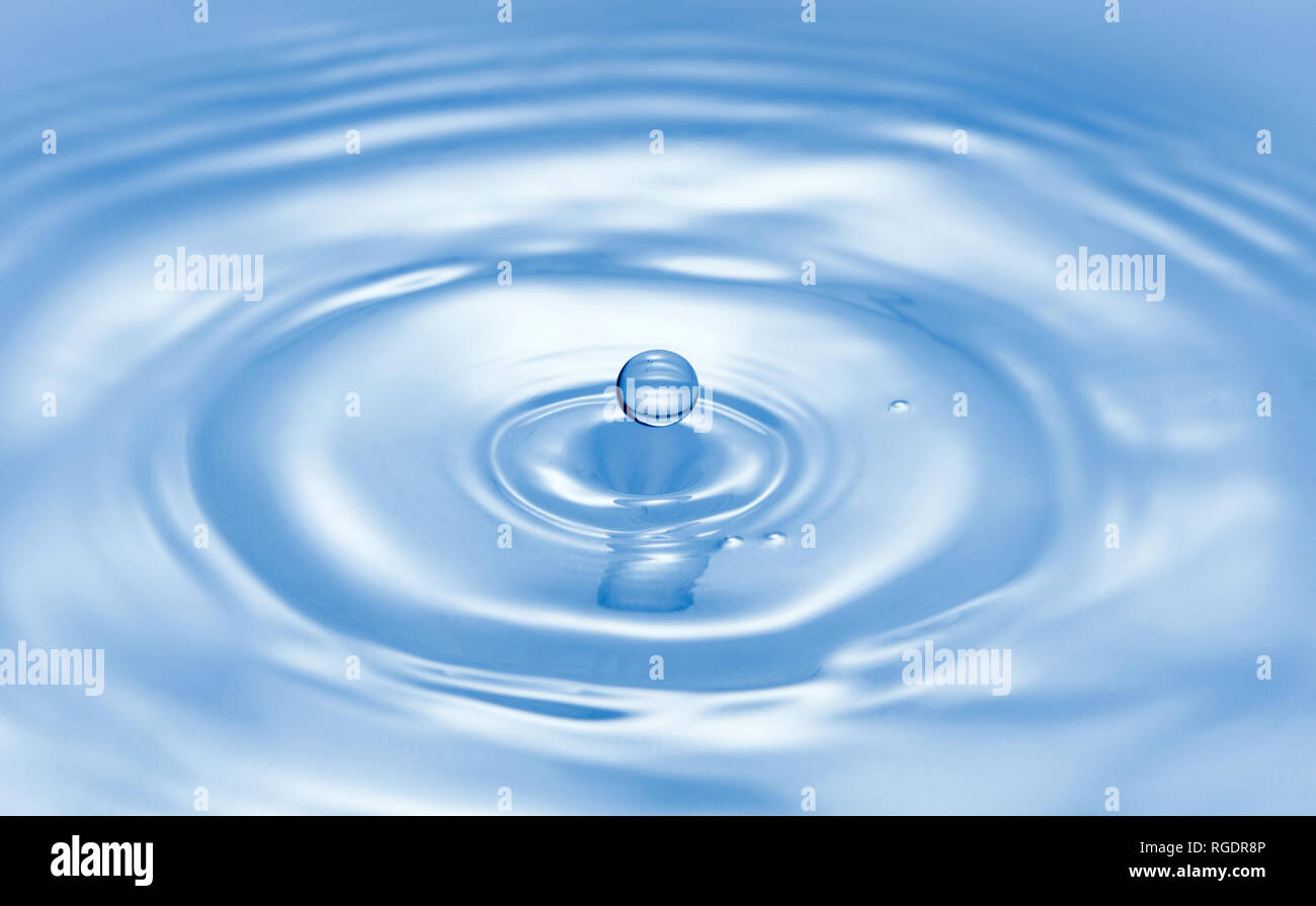 water splash on pure blue water surface Stock Photo - Alamy