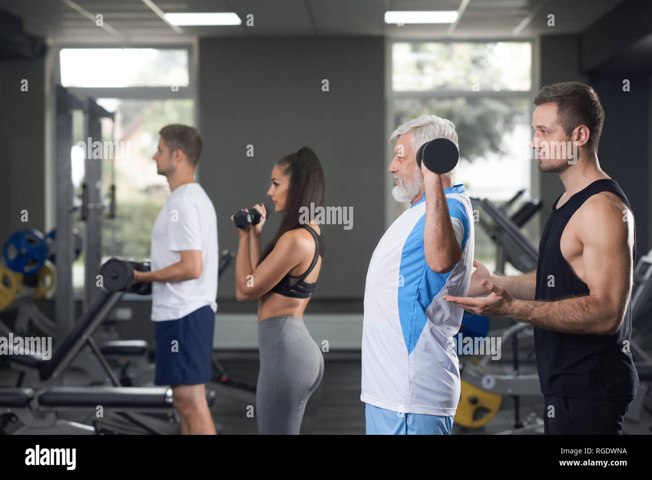 Daily indoor horizontal view of different people working in gym. Three ...