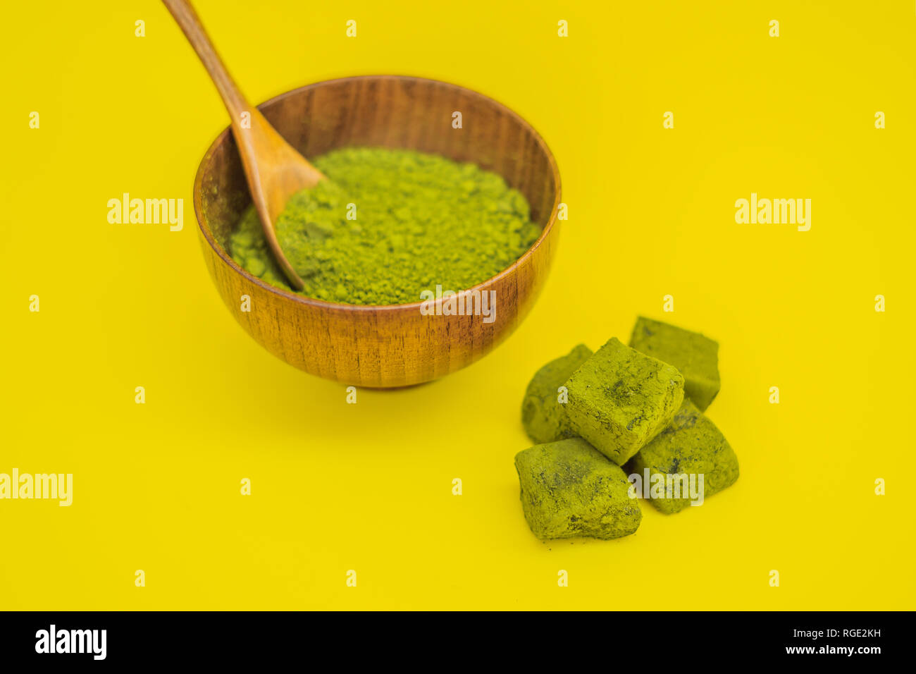 Matcha powder and candy made of matcha on yellow background. Homemade ...