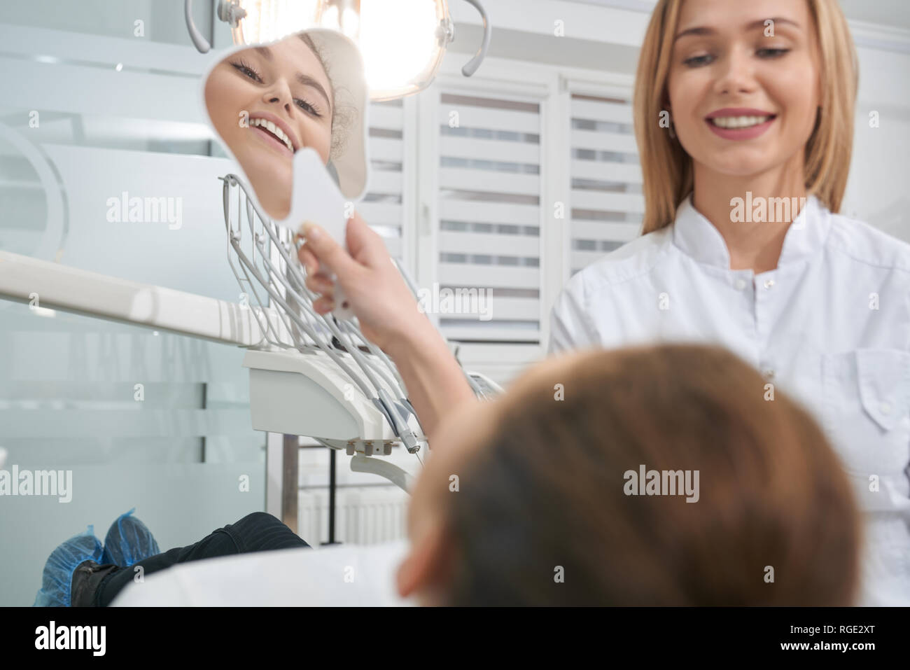 Client of dentistry clinic lying on dentist chair and looking at ...