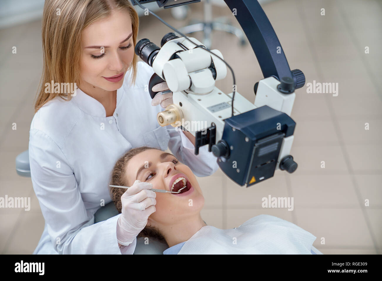 View from above of attractive female doctor checking teeth of patient ...