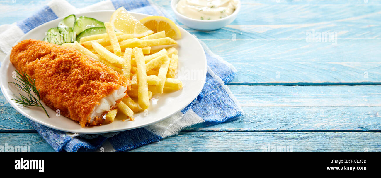 Crumbed deep fried fillet of cod served with potato chips and a ...