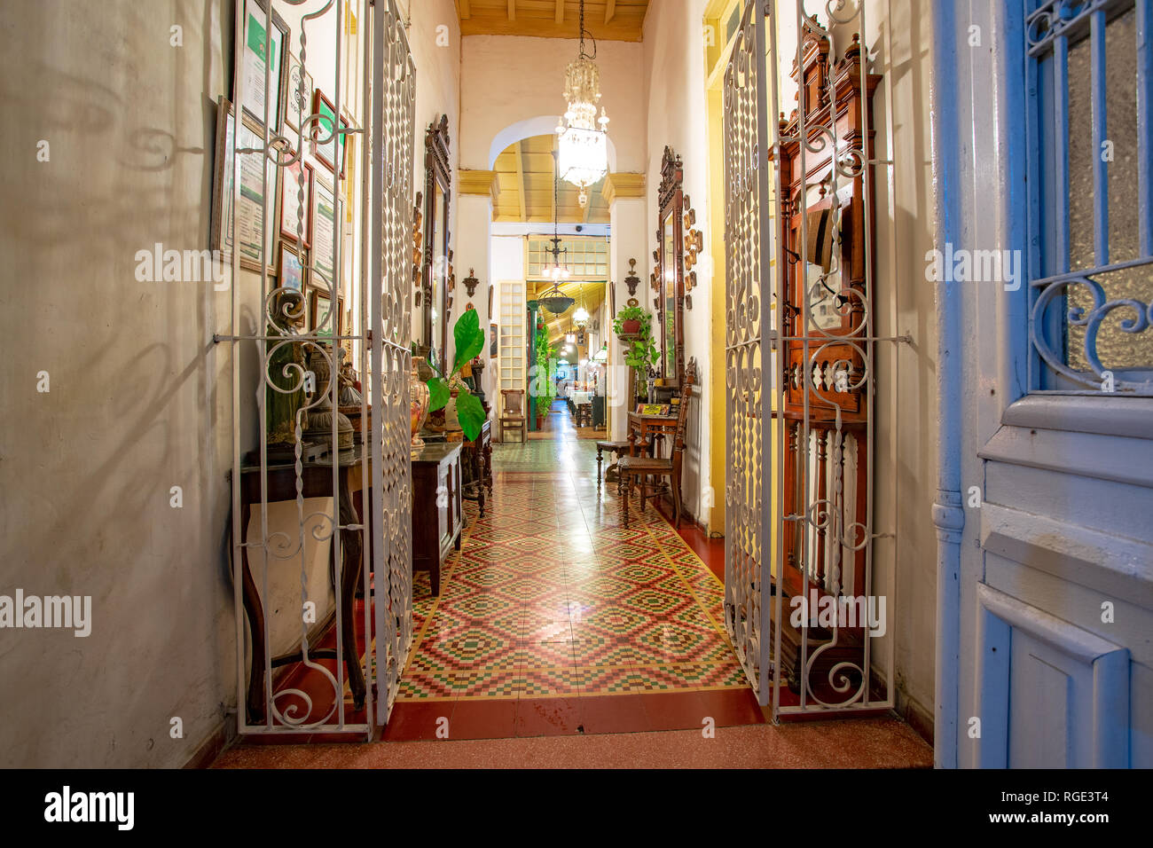 Entrance hall of a colonial house, lit with antique lamps and antique ...