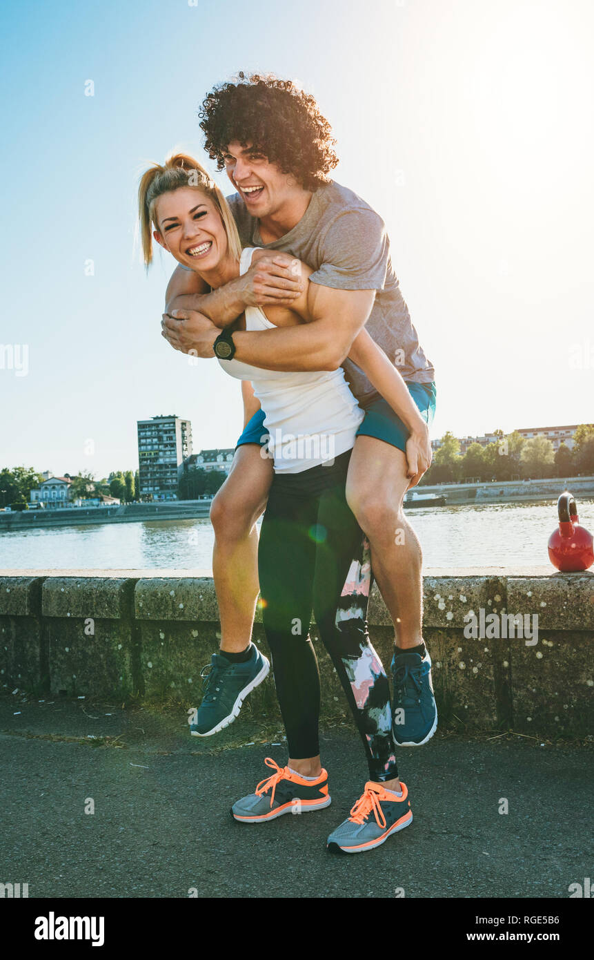 Young happy couple runners are having fun after training outdoors by ...